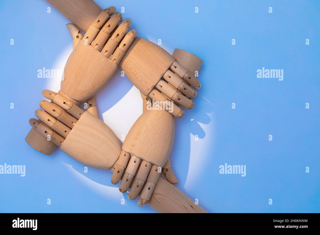 close up of hands holding each other. Two pairs of wooden prosthetic ...