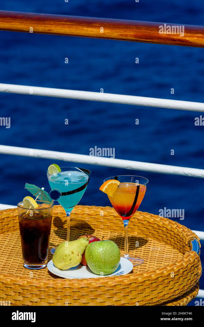 Assorted cocktails, served on a table with a plate of fruit Stock Photo ...