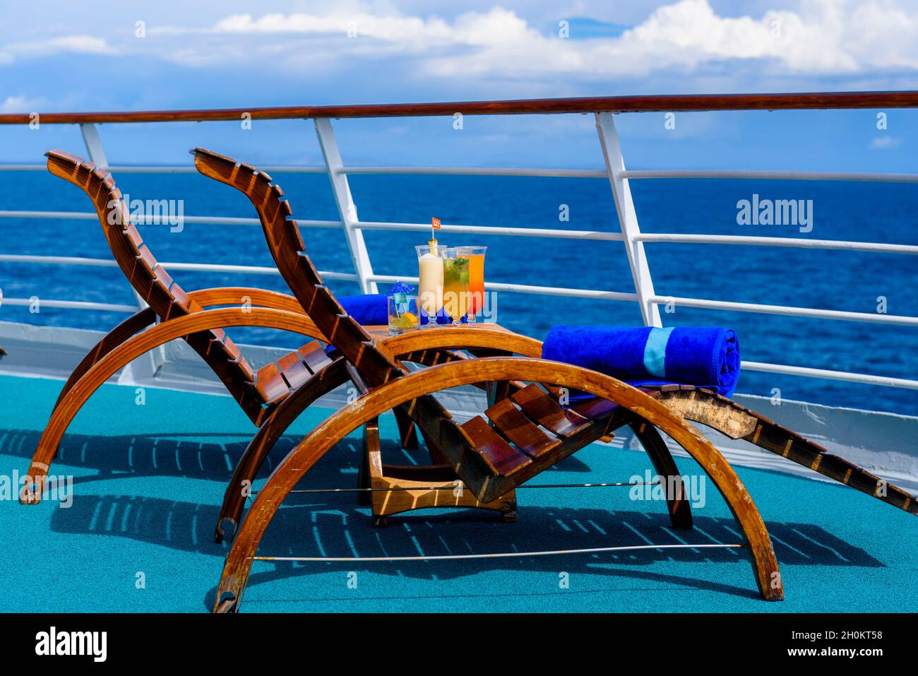Sun loungers to enjoy the ocean views, with a cocktail table next to it ...