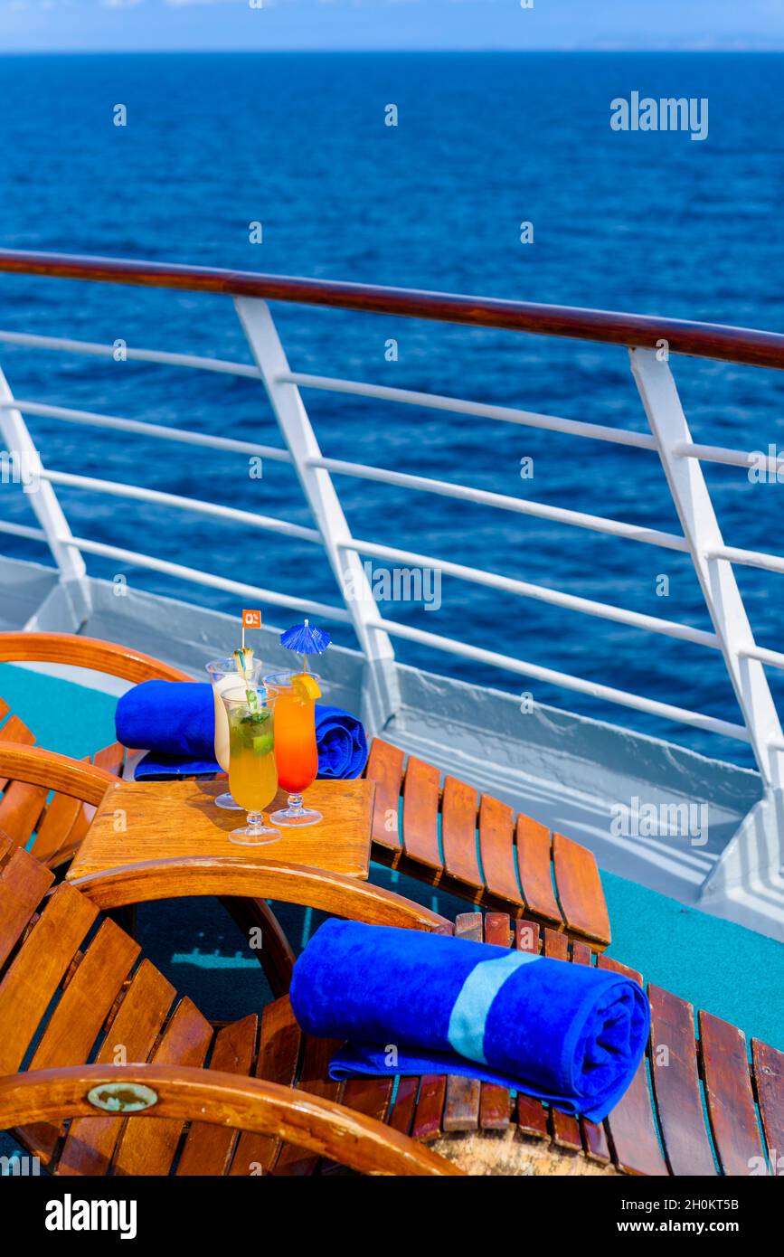 Sun loungers to enjoy the ocean views, with a cocktail table next to it ...