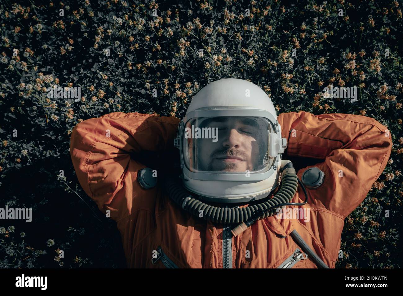 Closeup of cosmonaut wearing space suit and space helmet taking a nap ...