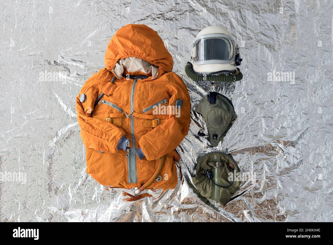 Flat lay of folded astronaut's orange space suit, space helmet and ...