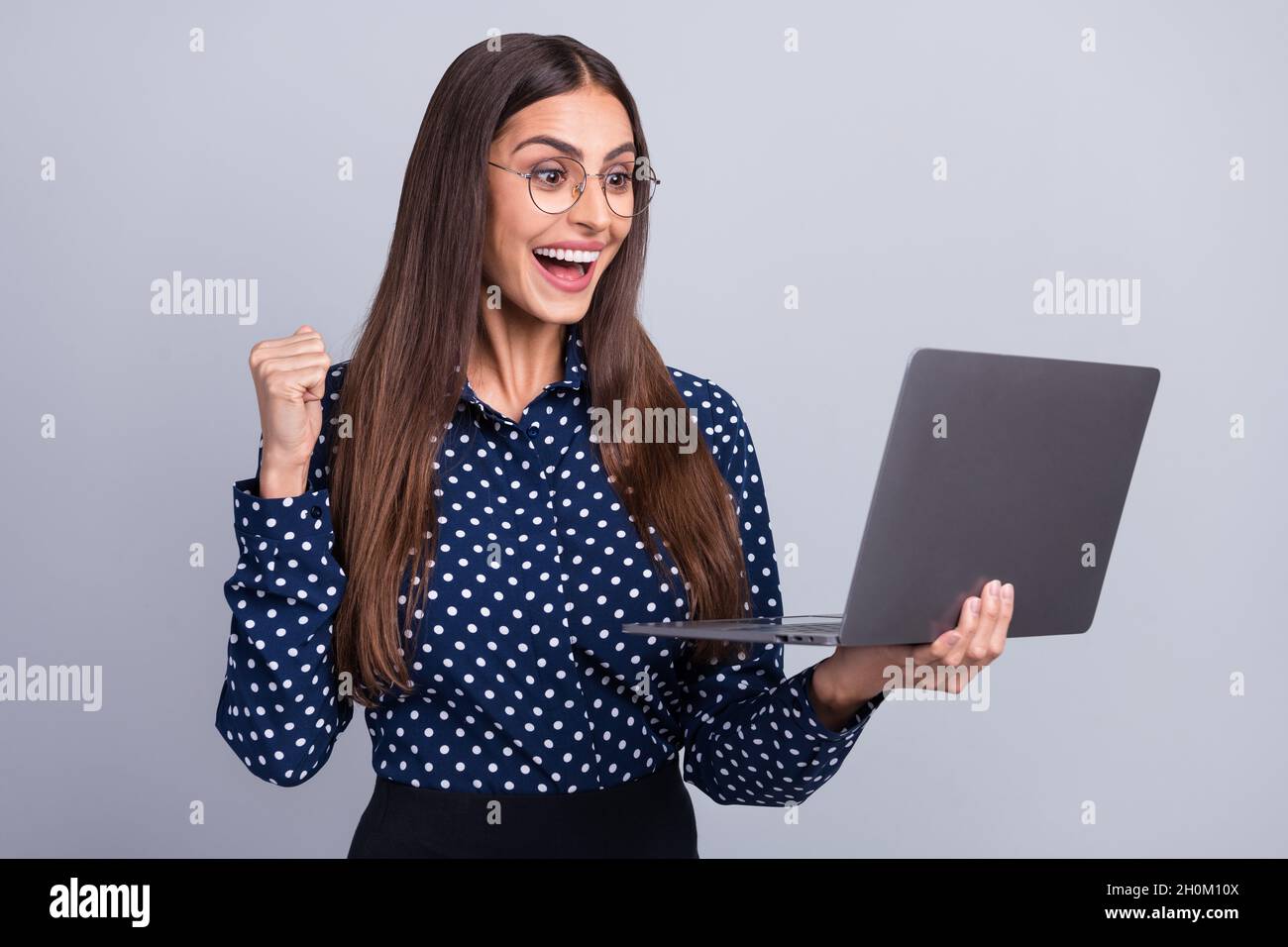 Photo of impressed millennial brunette lady look laptop wear blue shirt ...
