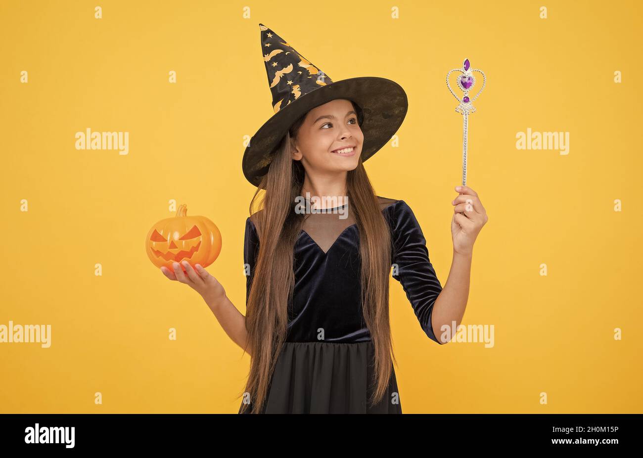 happy witch kid with magic wand and pumpkin jack o lantern wear costume ...