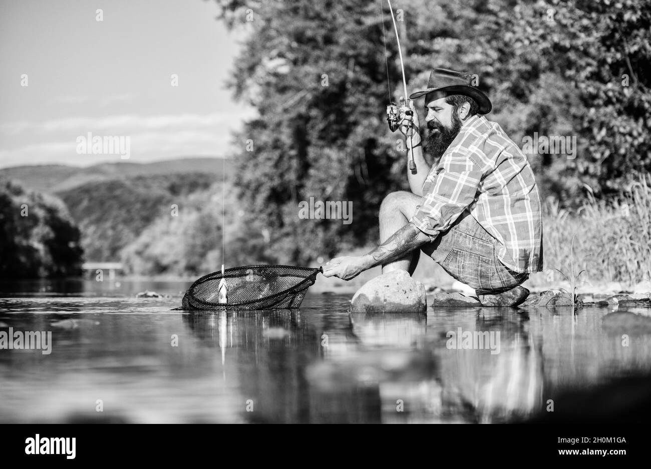 Man catching fish. Guy fly fishing. Successful fly fishing. Hobby for ...