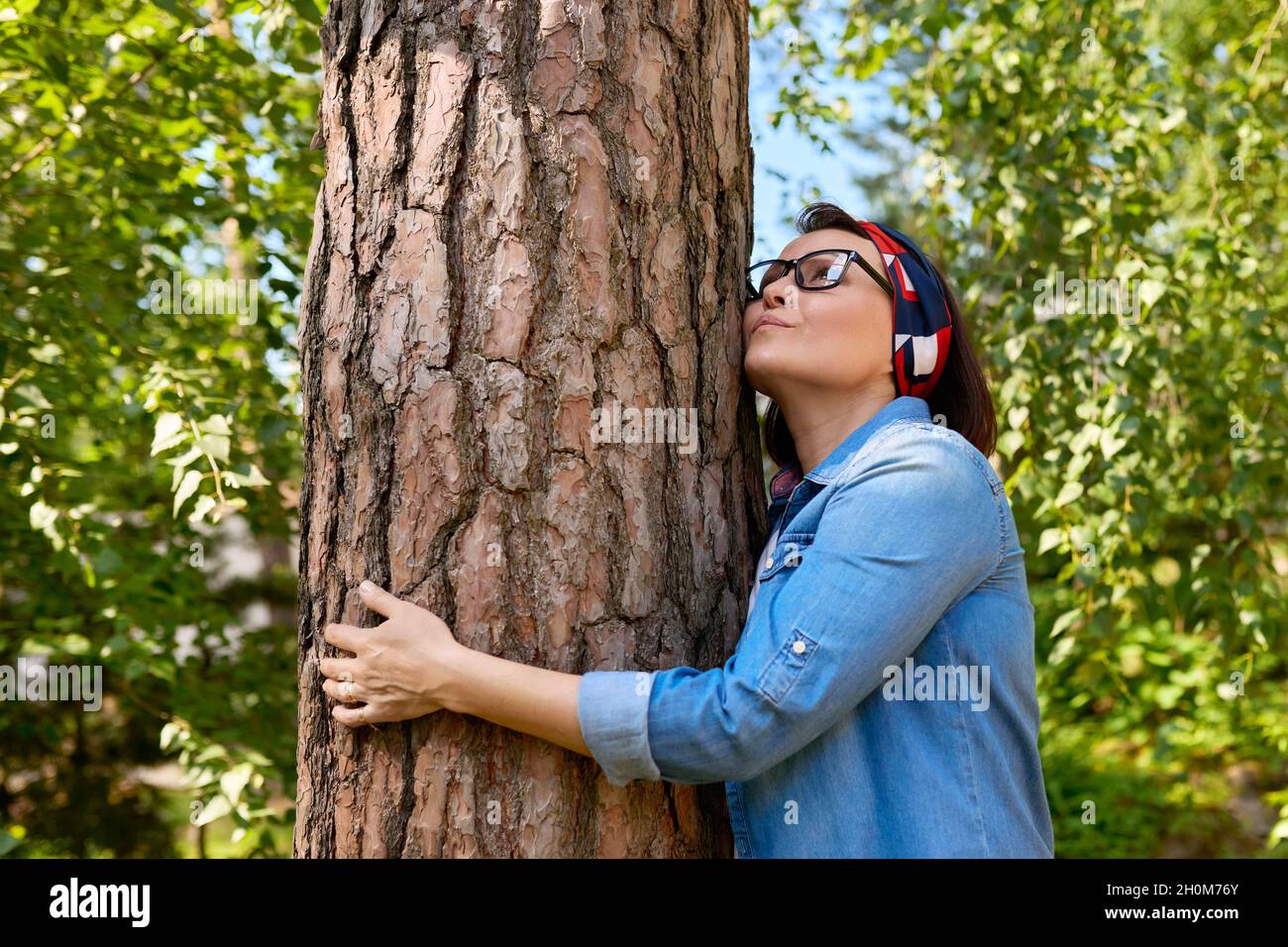 Middle aged woman hugging a tree, energy of nature Stock Photo - Alamy