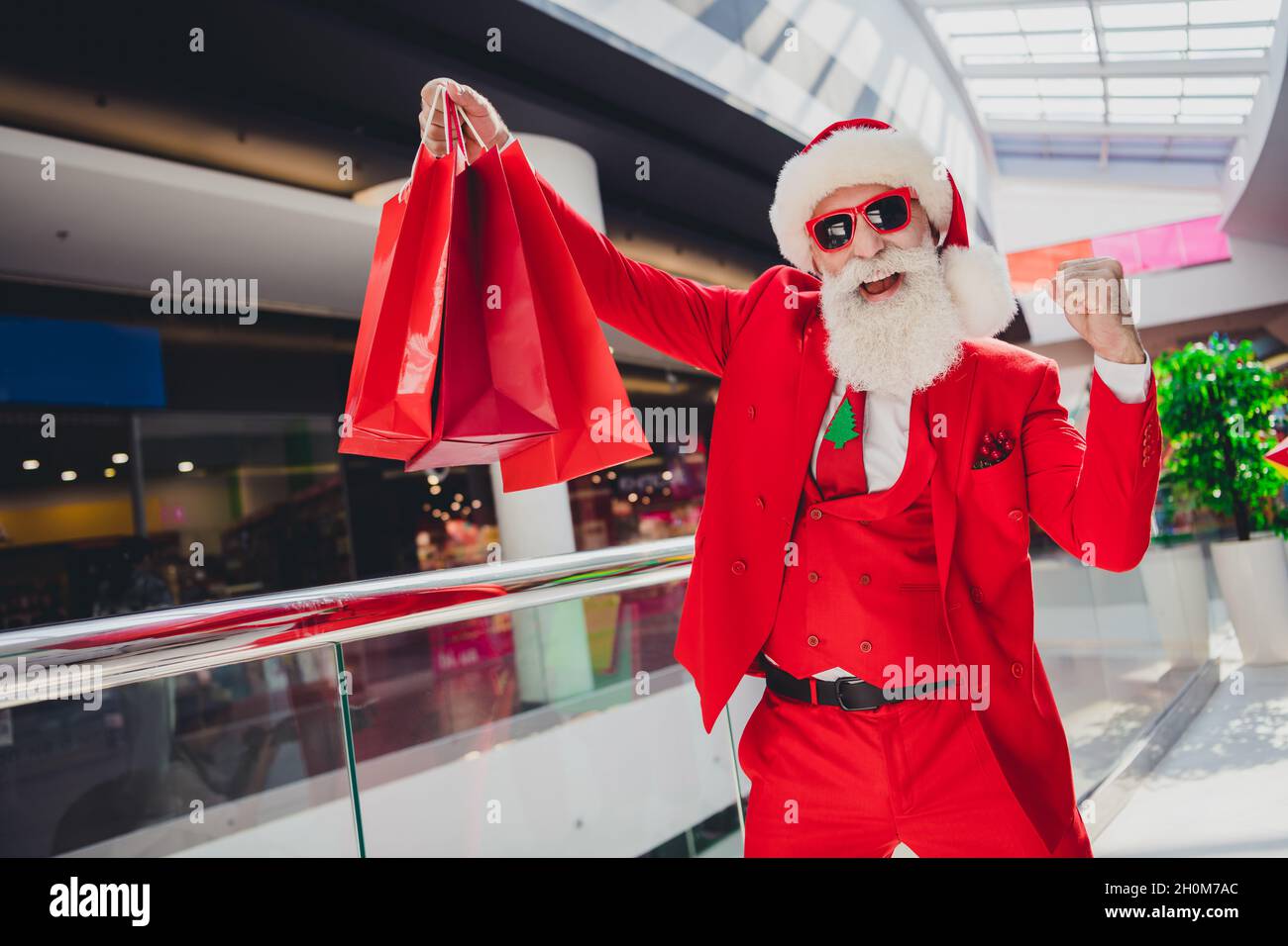 Portrait of attractive lucky cheerful elderly Santa buying nice eve ...