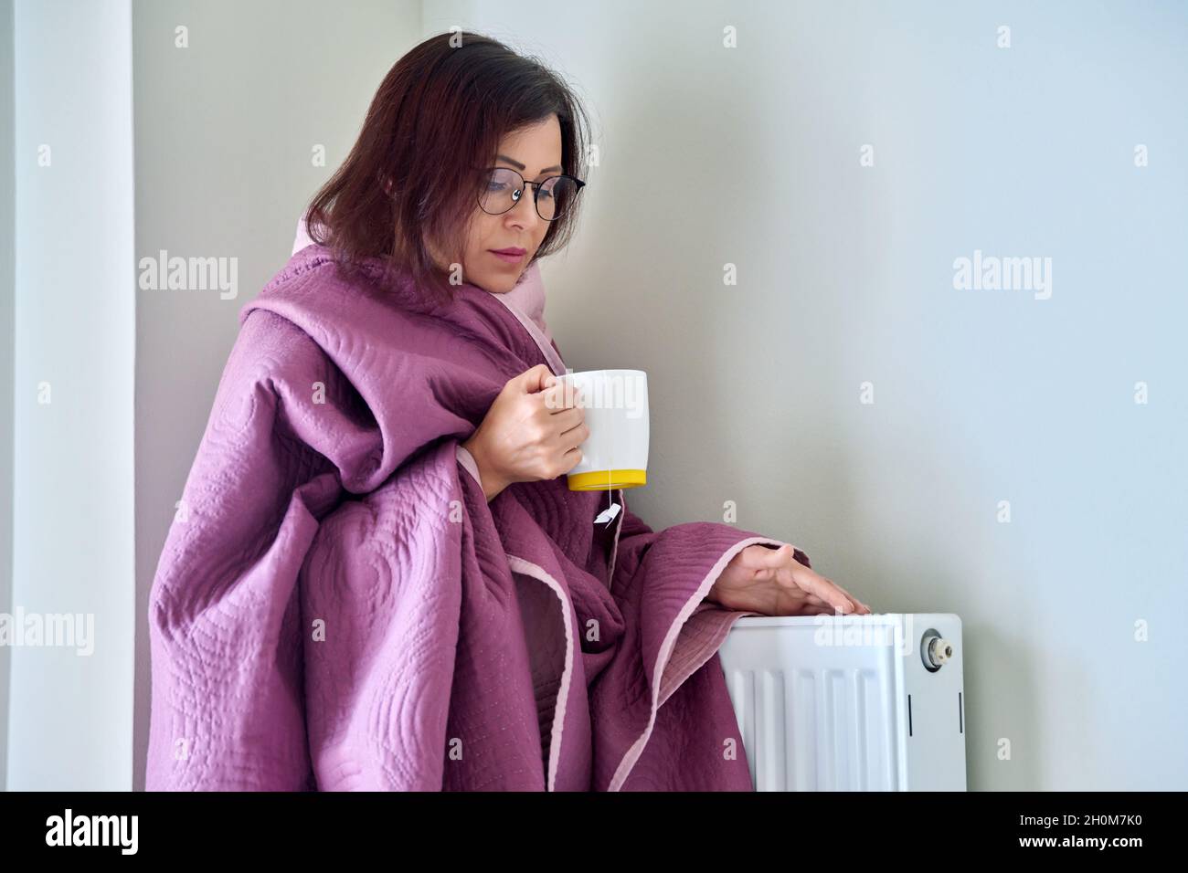 Woman warming herself heater hi-res stock photography and images - Alamy