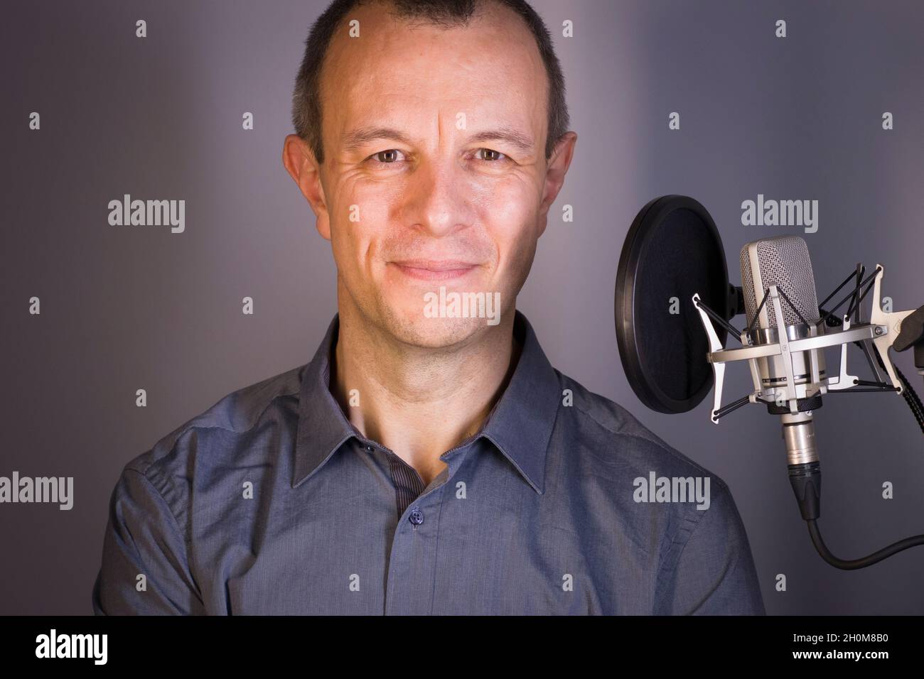 Voiceover artist voice actor in vocal recording studio with larg ...