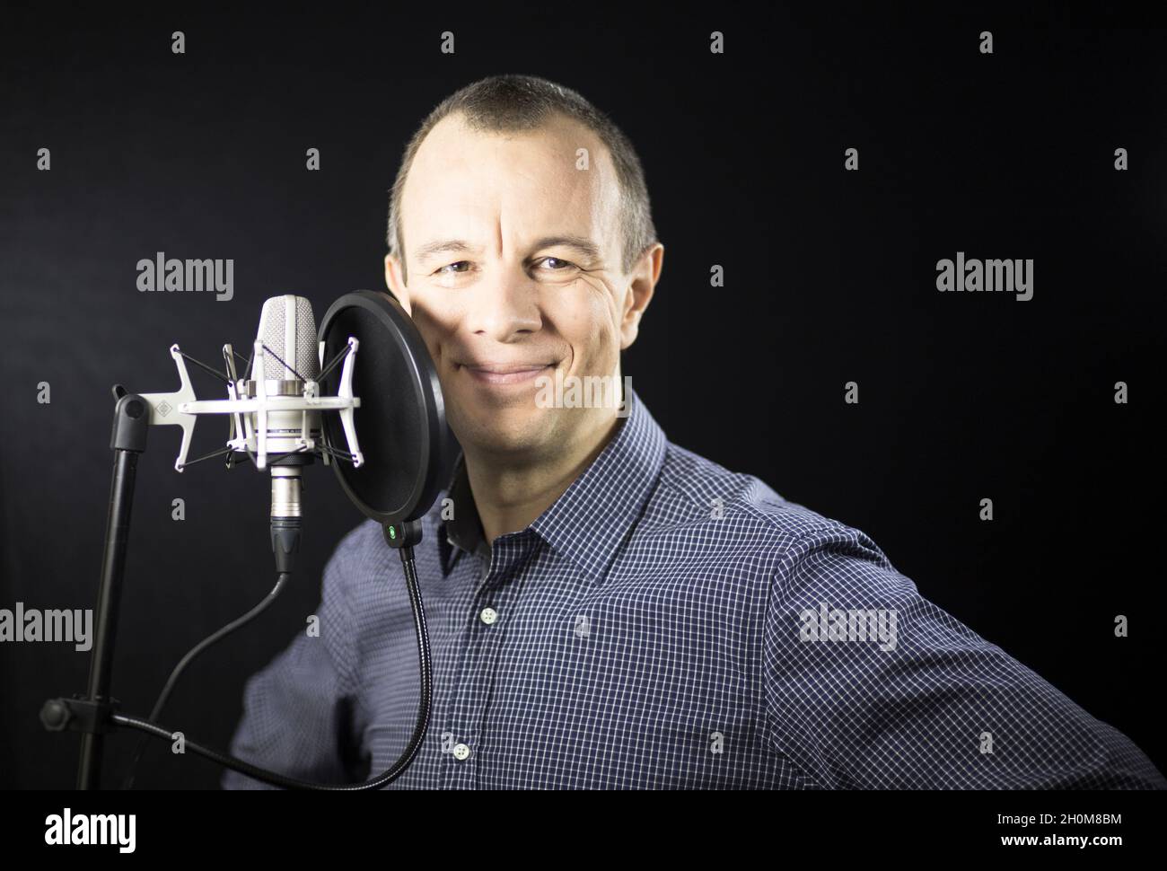 Voiceover artist voice actor in vocal recording studio with larg ...