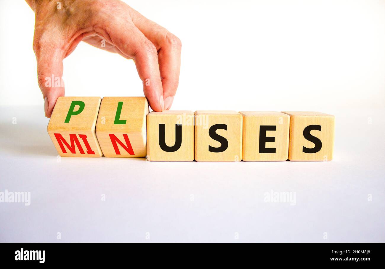 Pluses and minuses symbol. Businessman turns wooden cubes and changes ...