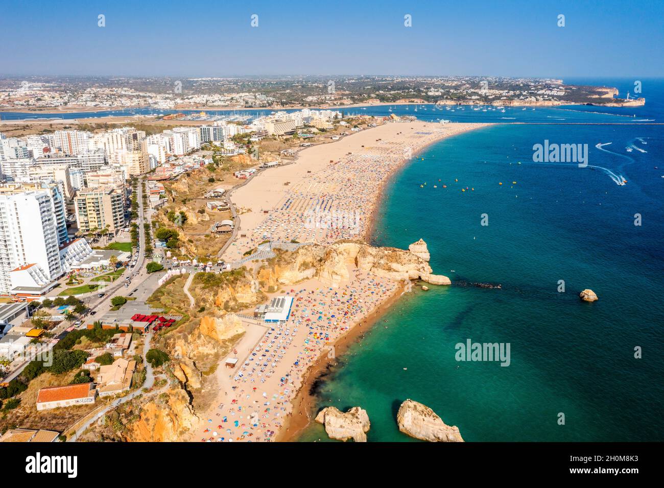 Aerial view of touristic Portimao with wide sandy Rocha beach full of ...