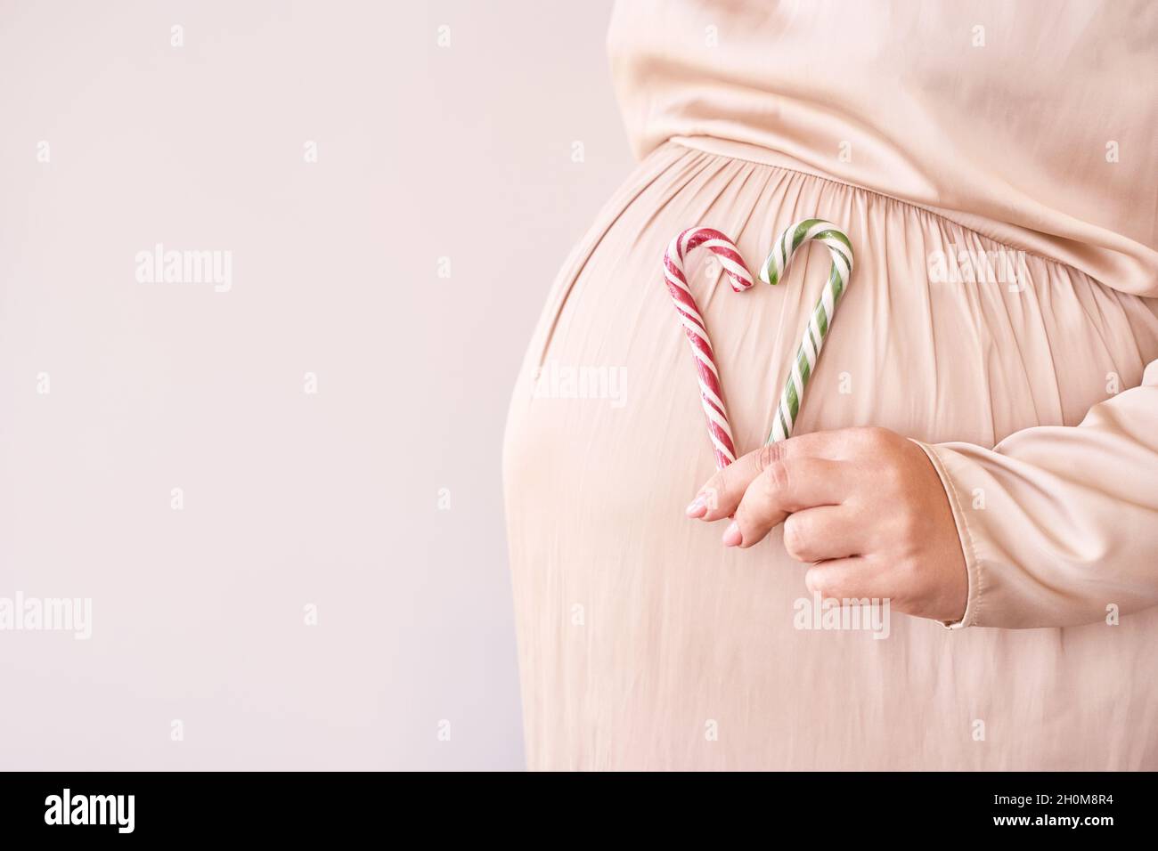 Pregnant skin care. Morning body routine. Woman belly candy cane. Heart ...