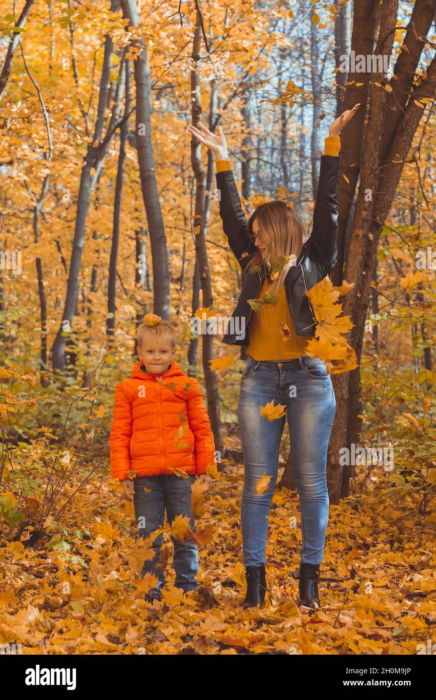 Single parent family playing with autumn leaves in park. Happy mom and ...