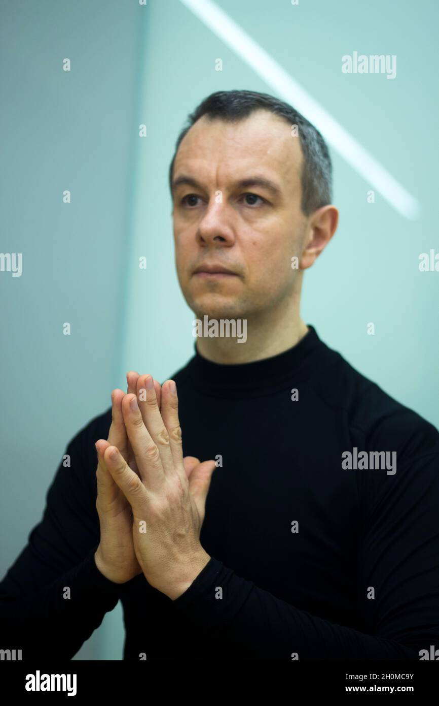 Male instructor yoga teacher teaching asana pose with mudra hand ...