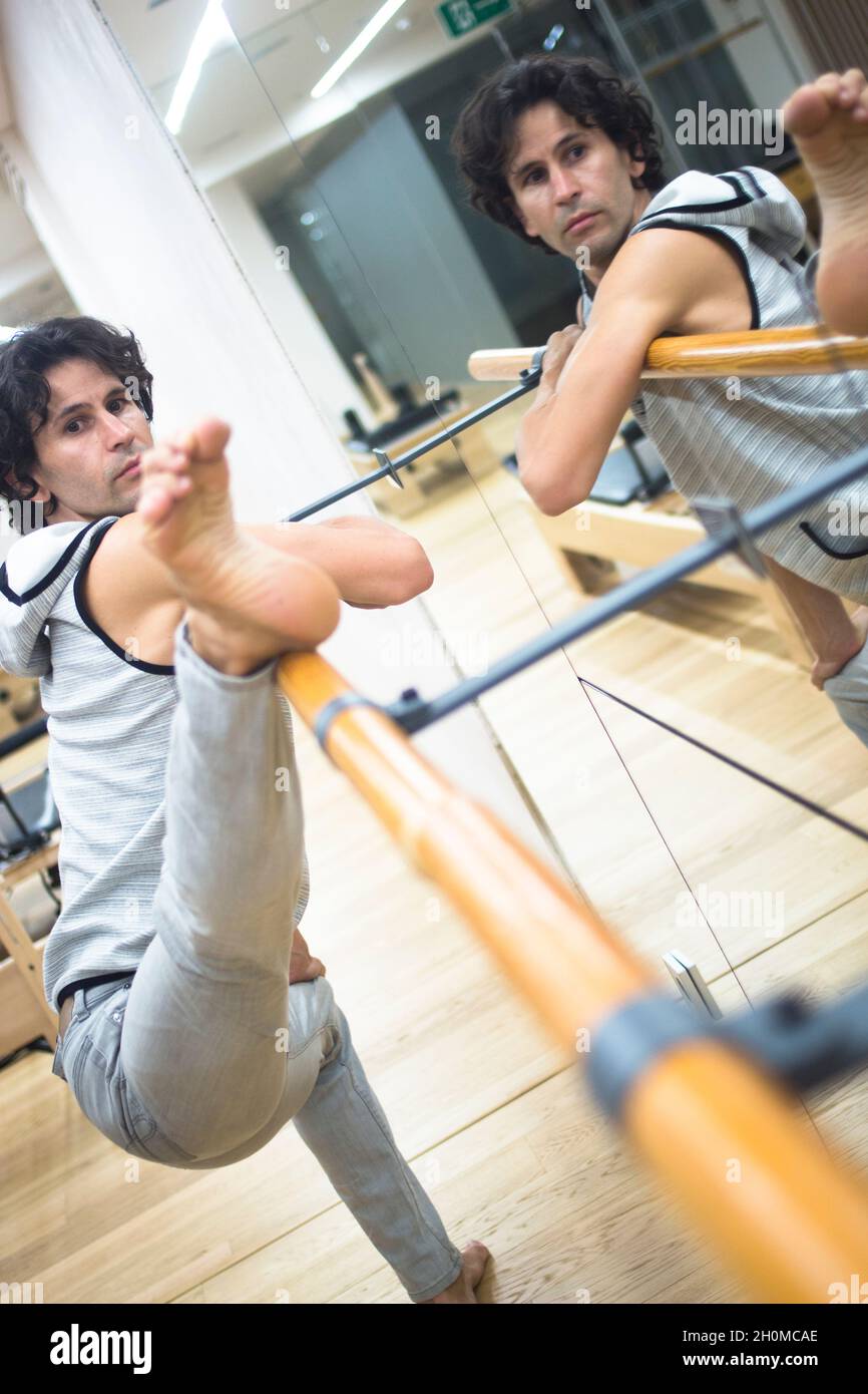 Man dancer dance teacher stetching in gym fitness studio doing advanced ...