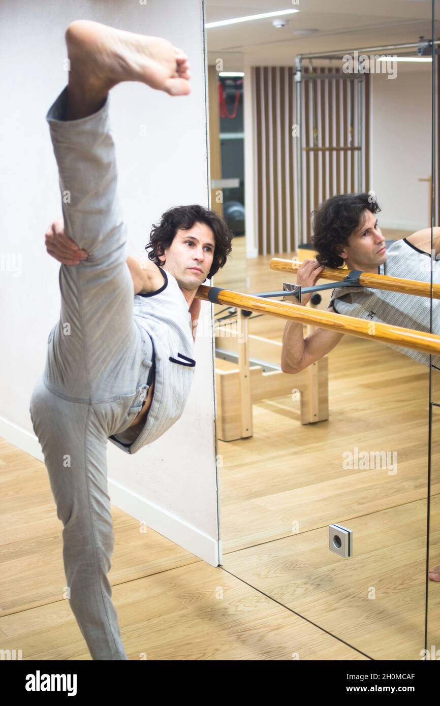 Man dancer dance teacher stetching in gym fitness studio doing advanced ...