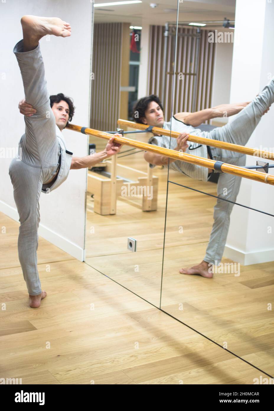 Man dancer dance teacher stetching in gym fitness studio doing advanced ...