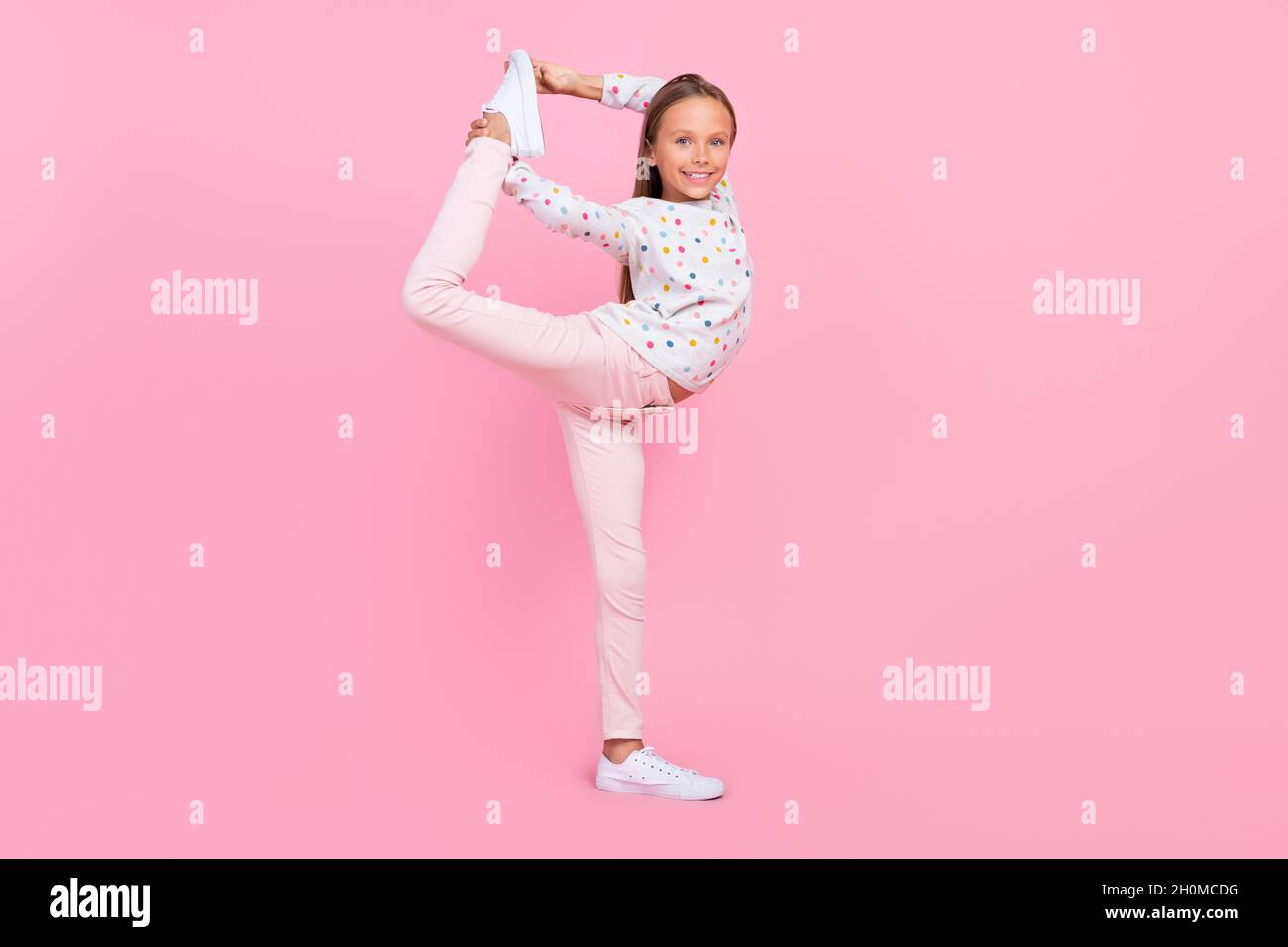 Photo of cheerful small acrobat lady stretch leg warm up wear dotted ...