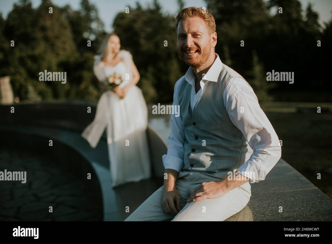 Closeup of the young newlywed man sitting in front of his young bride ...