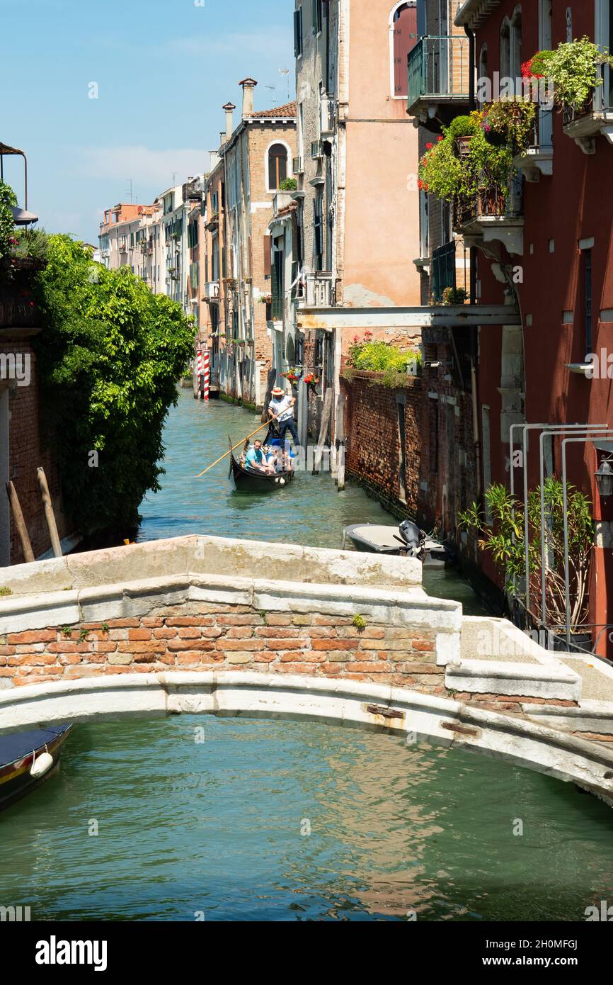 Venice, Italy - May 18th 2018: Historic footbridge and a narrow canal ...