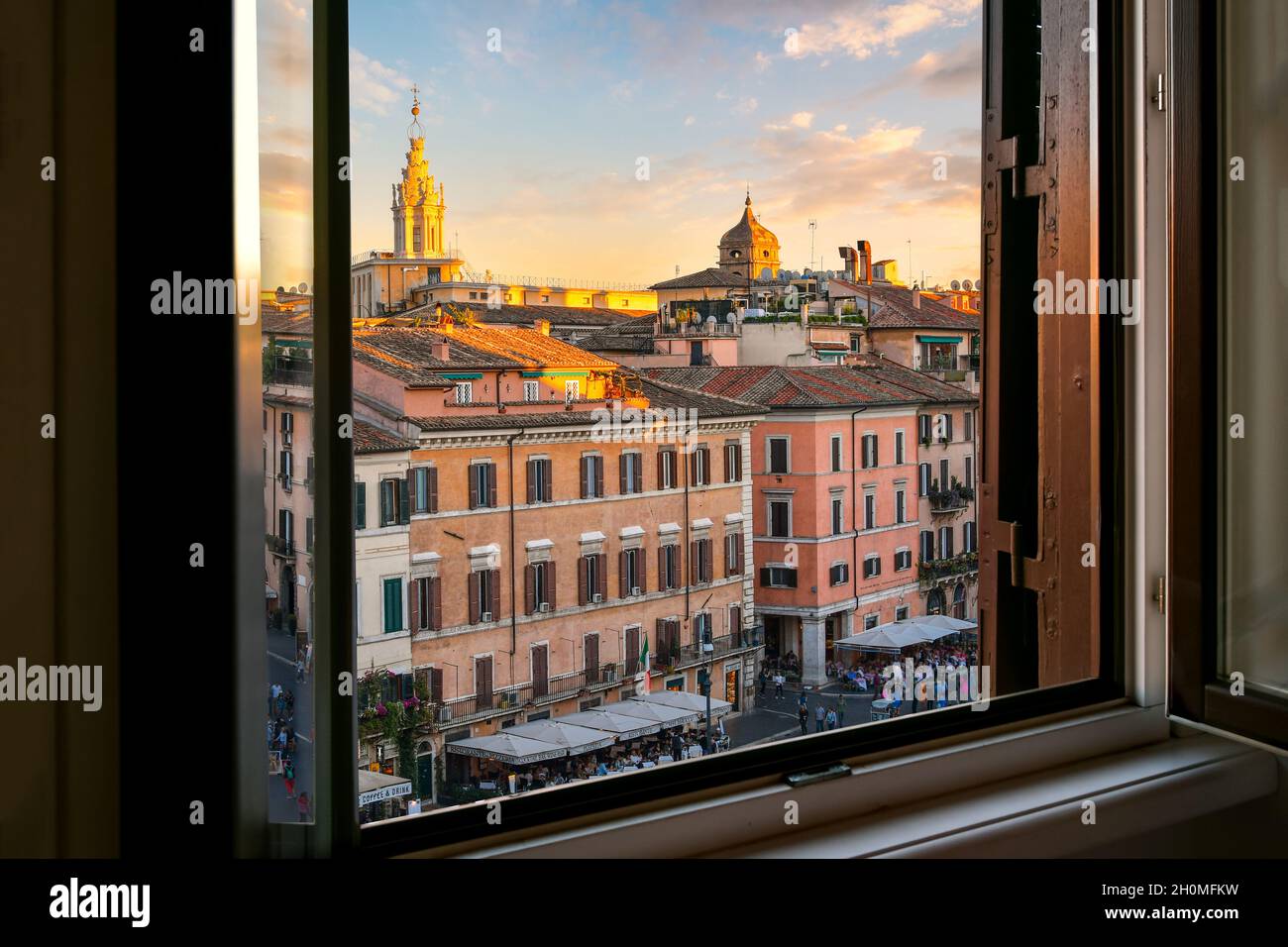 View through an open window above Piazza Navona at sunset showing the ...