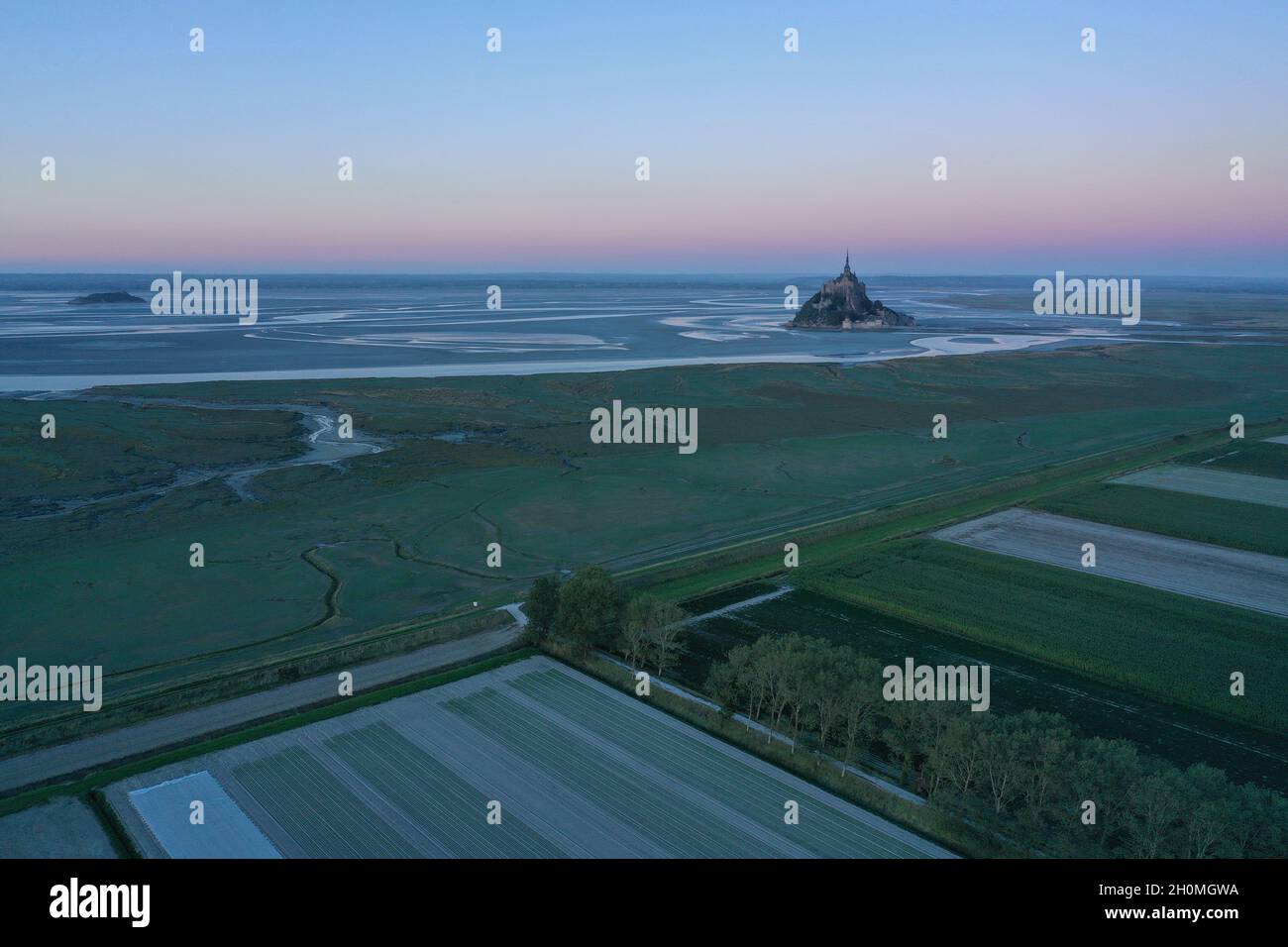 Le Mont Saint Michel castle surrounded by a winding stream on the ...