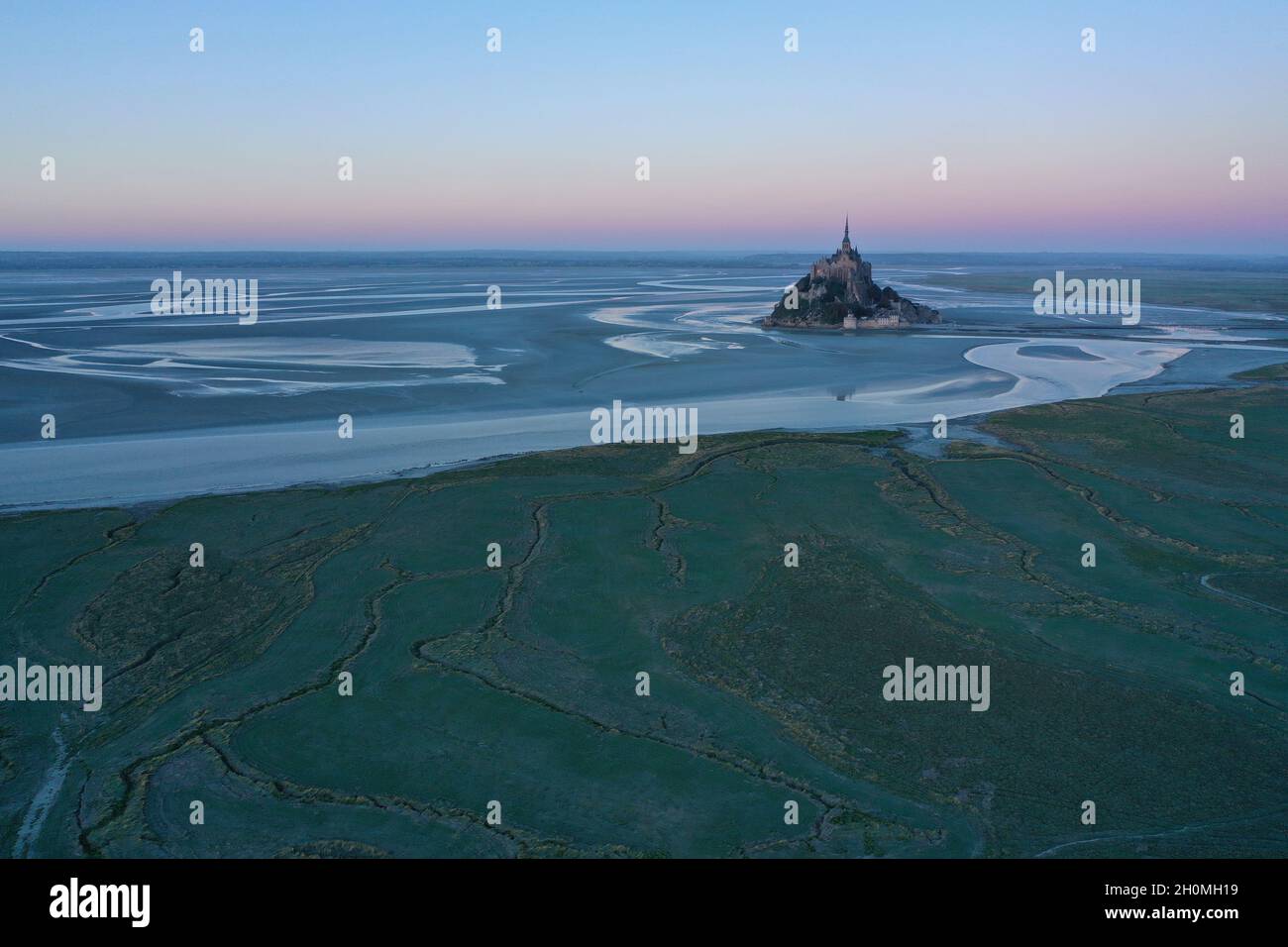 Le Mont Saint Michel castle surrounded by a winding stream on the ...