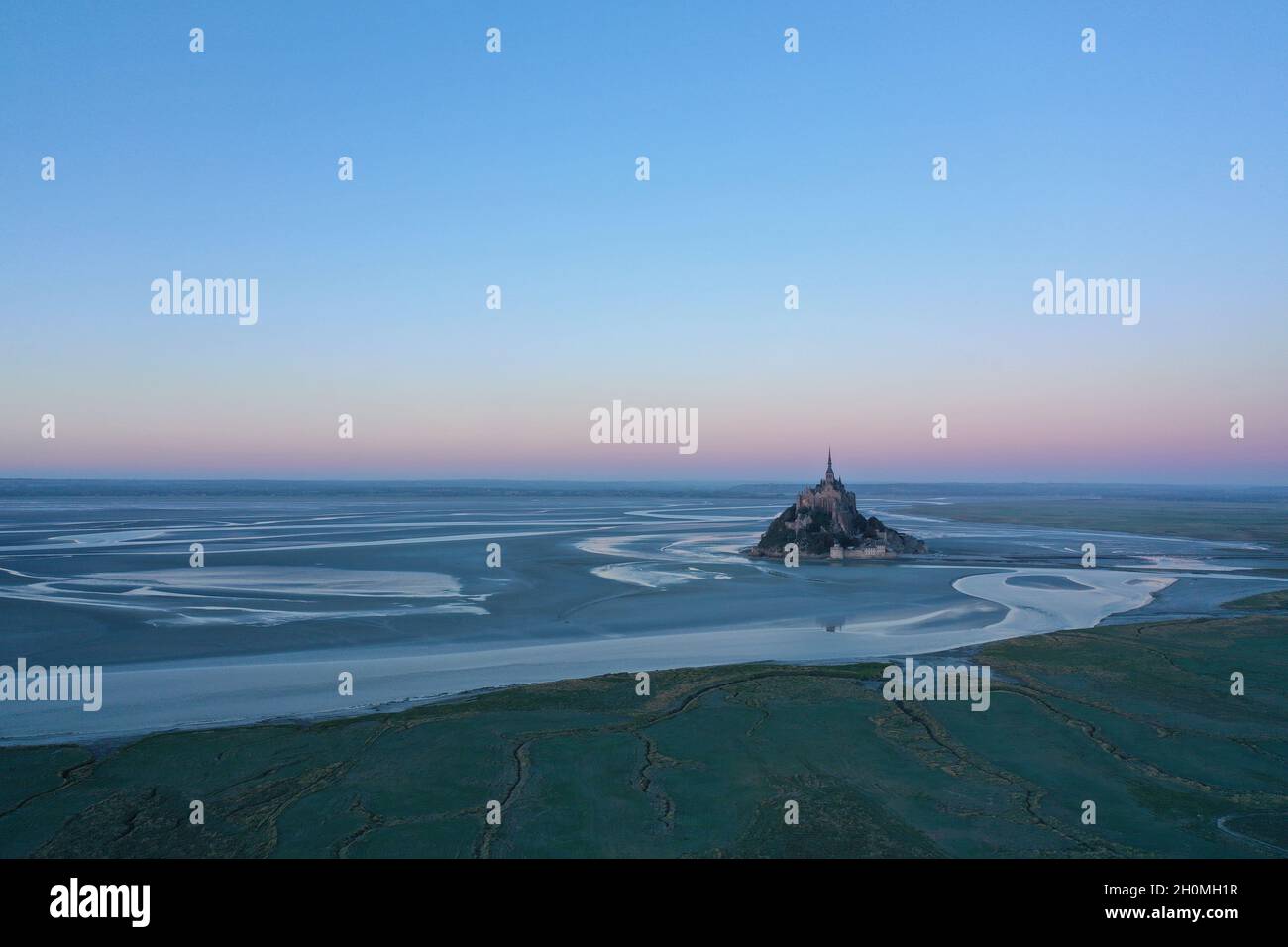Le Mont Saint Michel castle surrounded by a winding stream on the ...