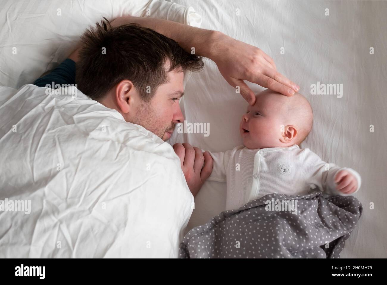 Sleeping father and cute child resting together in bed Stock Photo - Alamy