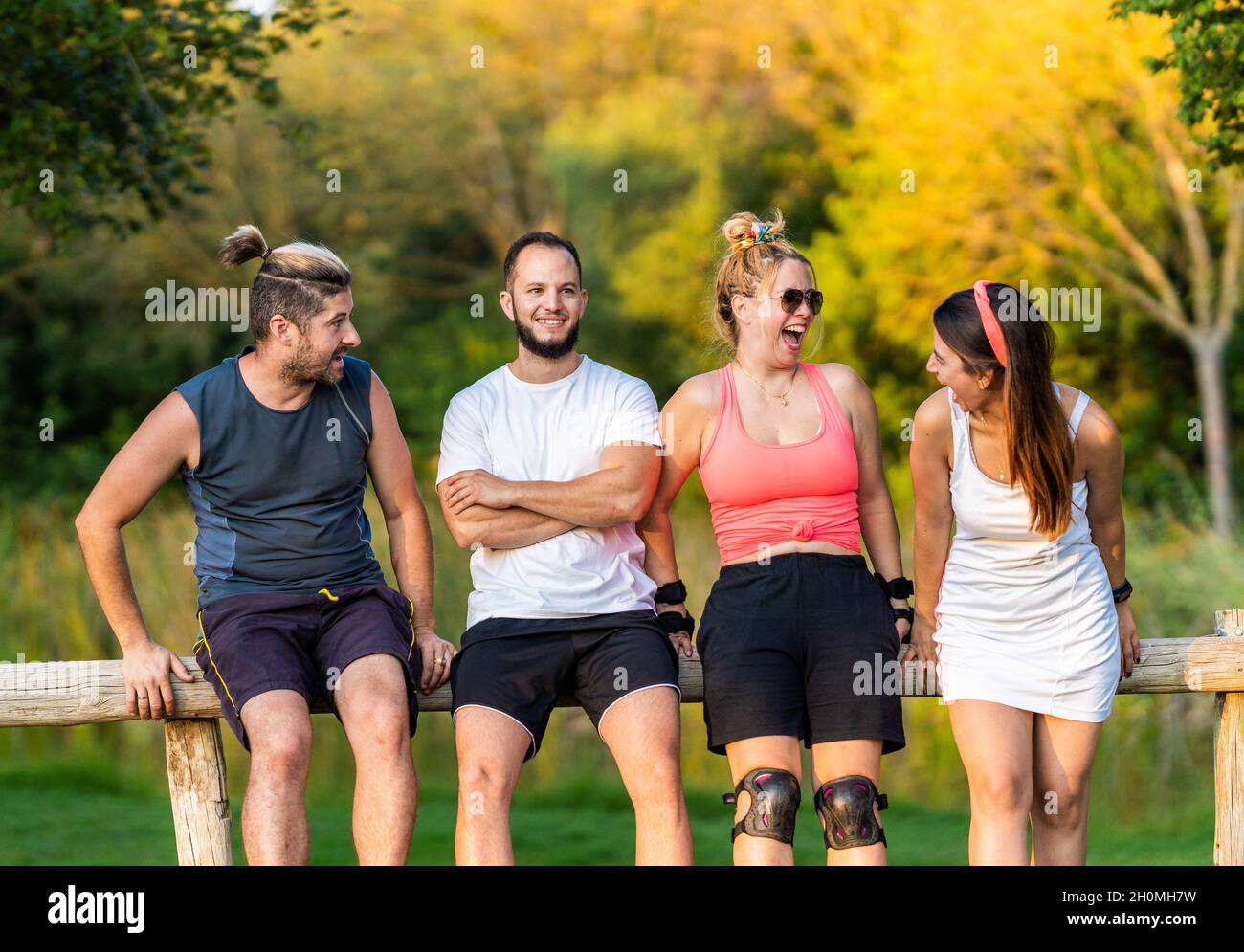 Group of friends laughing while resting in a railing in a park Stock ...