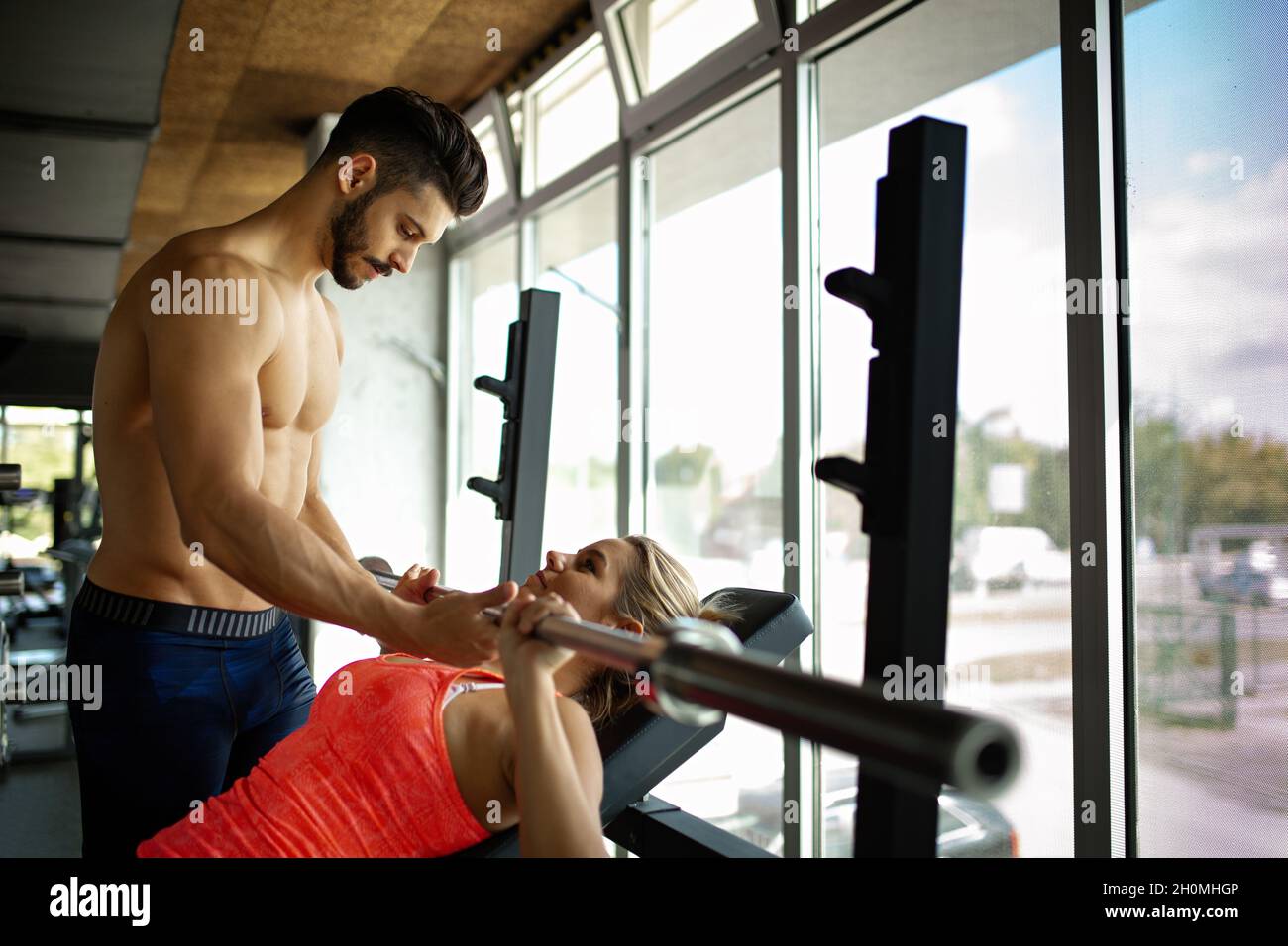 Personal trainer helping a woman to working out in gym. Sport people ...