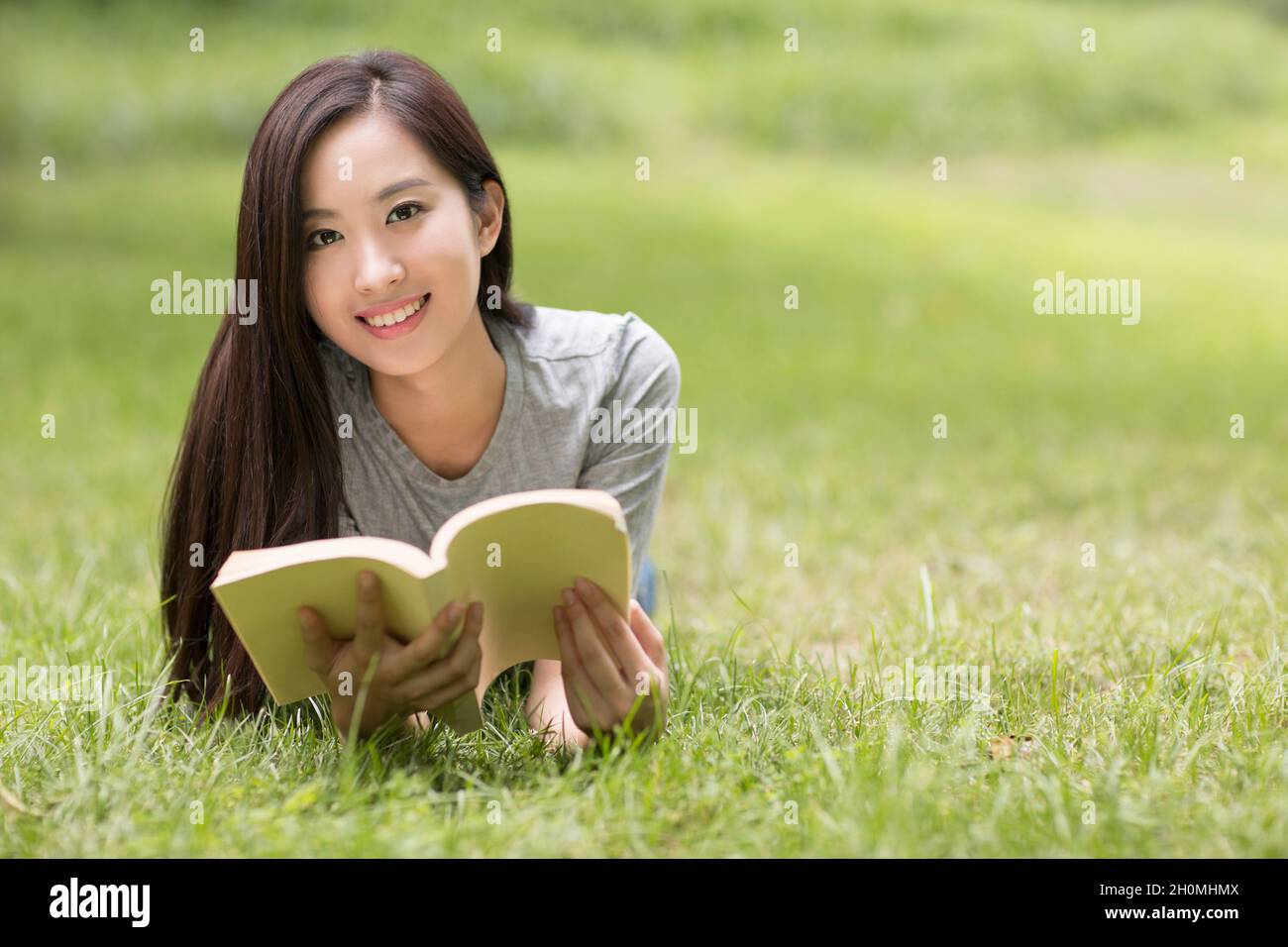 Woman lying on lawn reading hi-res stock photography and images - Alamy