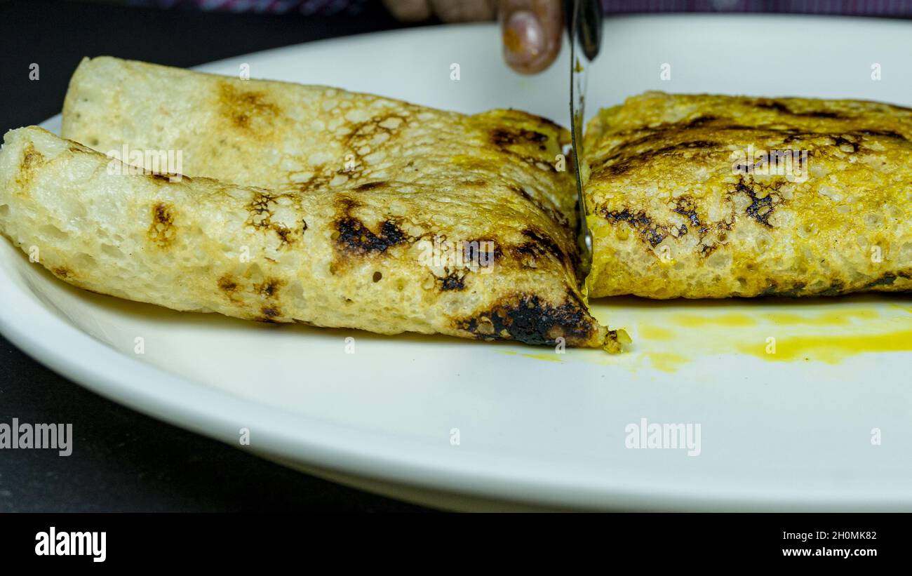 Traditional Indian cuisine. Close-UP Cut The Vegetarian Dosa With A ...