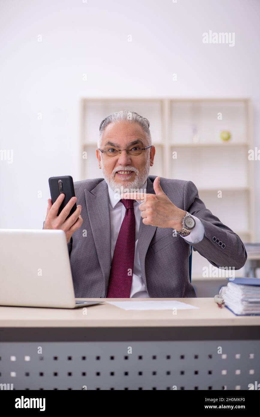 Old employee working in the office Stock Photo - Alamy