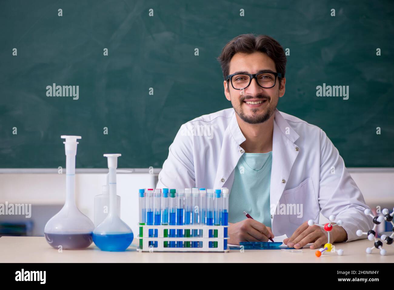 Young chemist in front of blackboard Stock Photo - Alamy