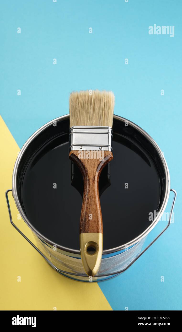 Vertical shot of Wooden paint brush on top of black color paint ...