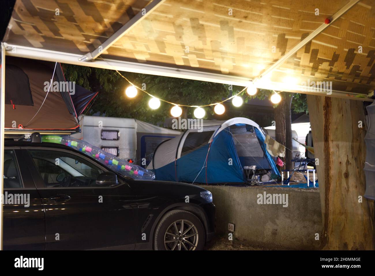 the night panorama inside a campsite seen from the veranda of a caravan ...