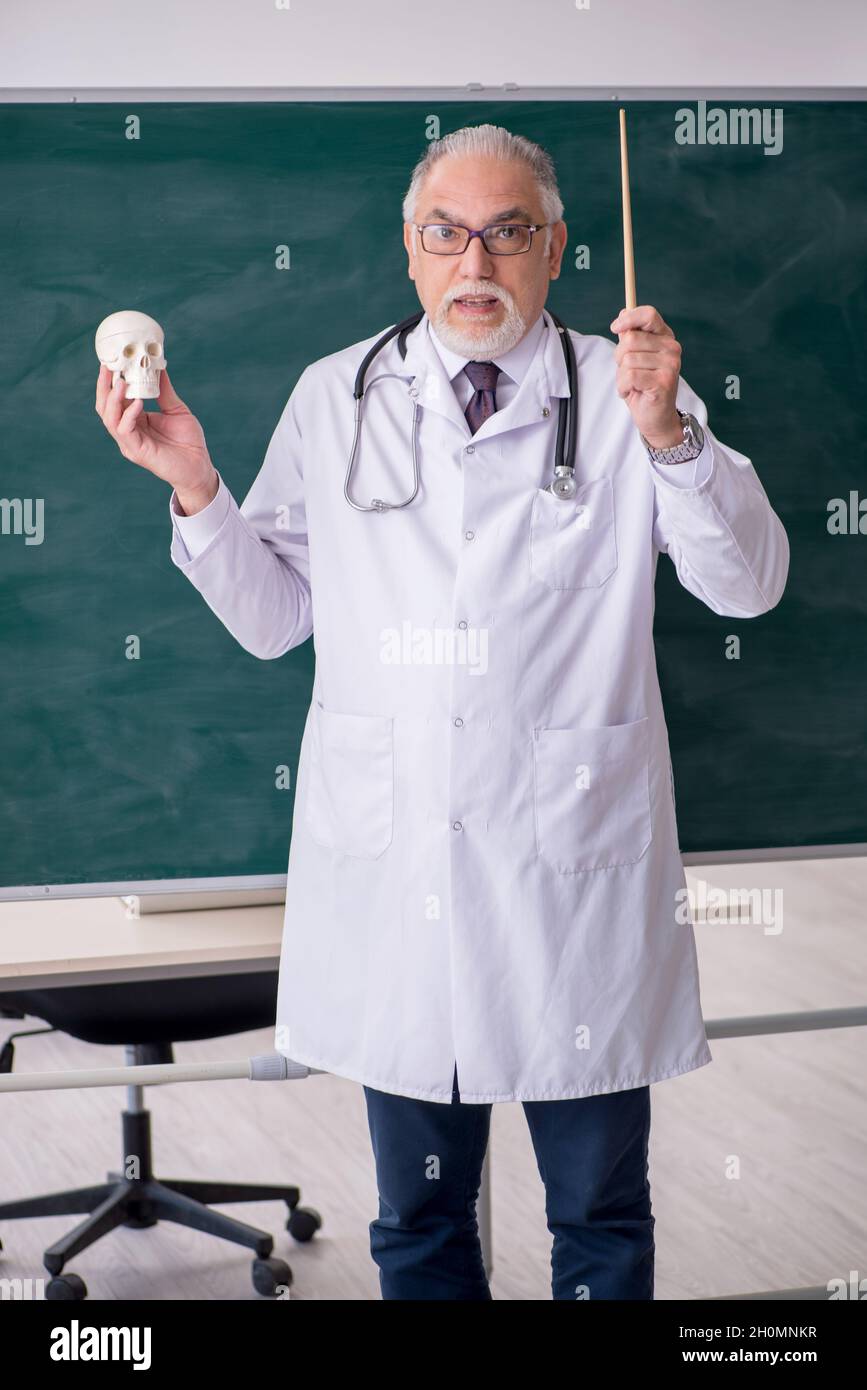 Old doctor teacher in front of blackboard Stock Photo - Alamy