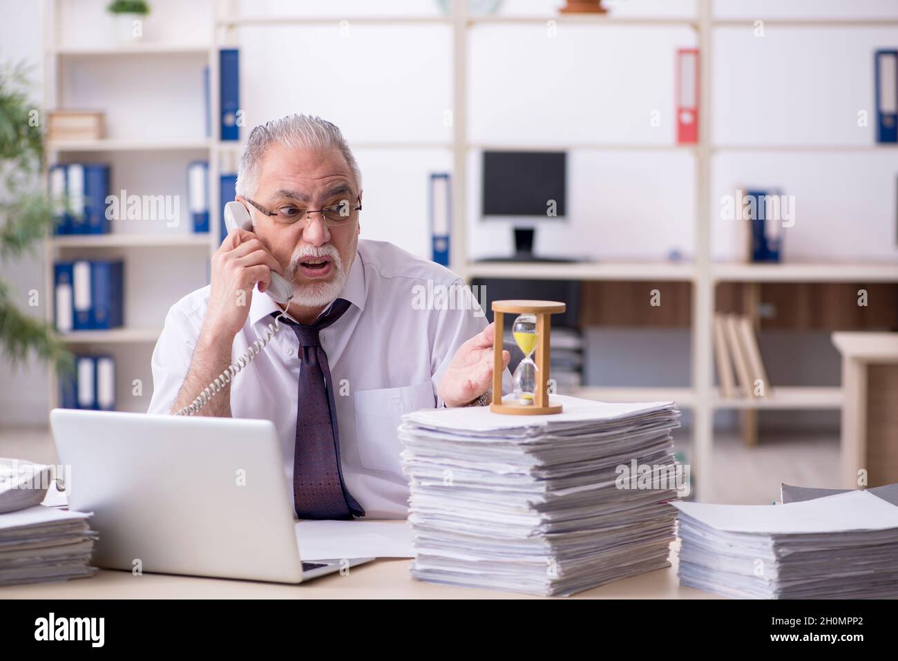 Old businessman employee in time management concept Stock Photo - Alamy