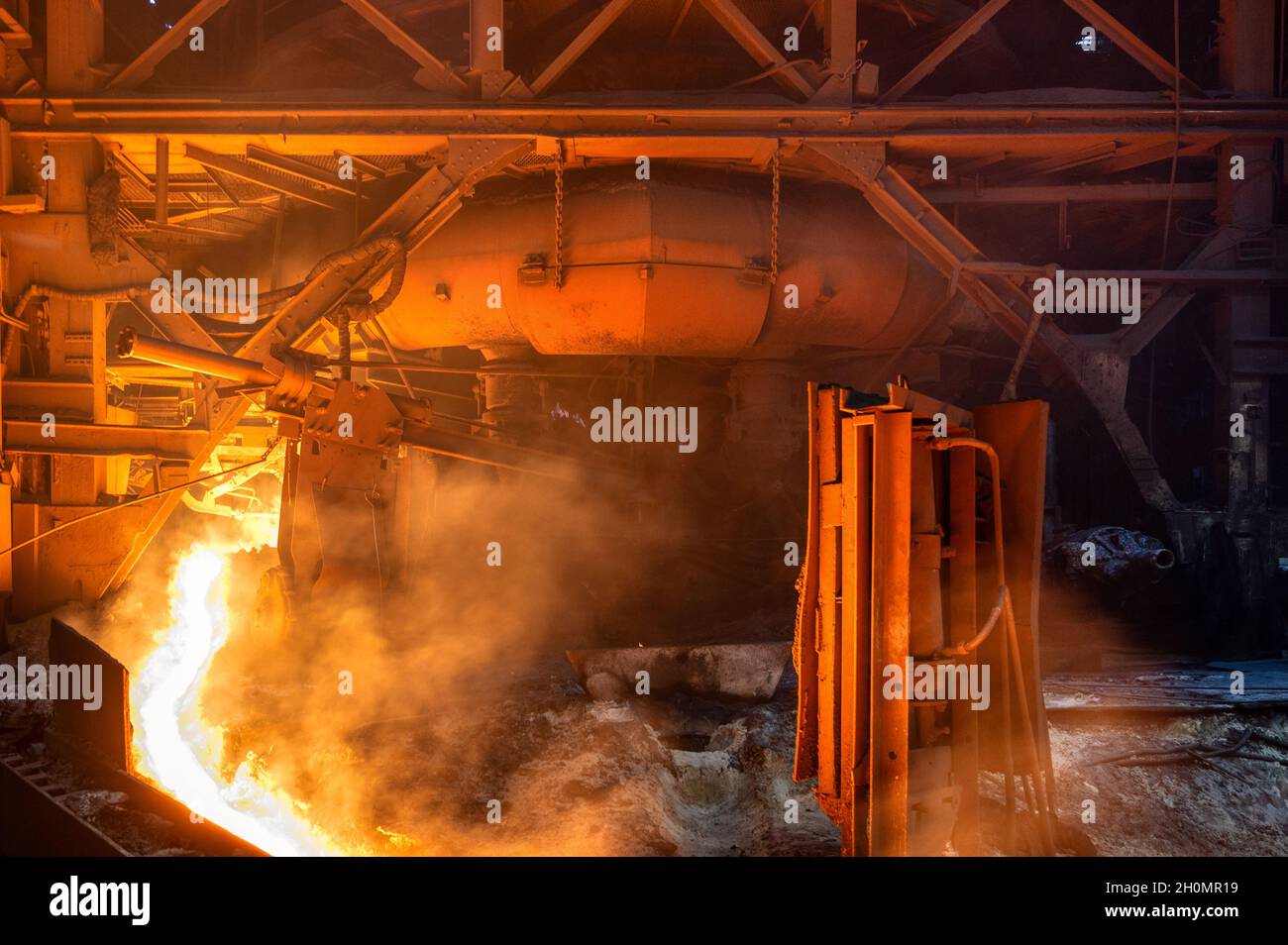 A stream of hot metal, molten steel flowing along a guide chute Stock ...