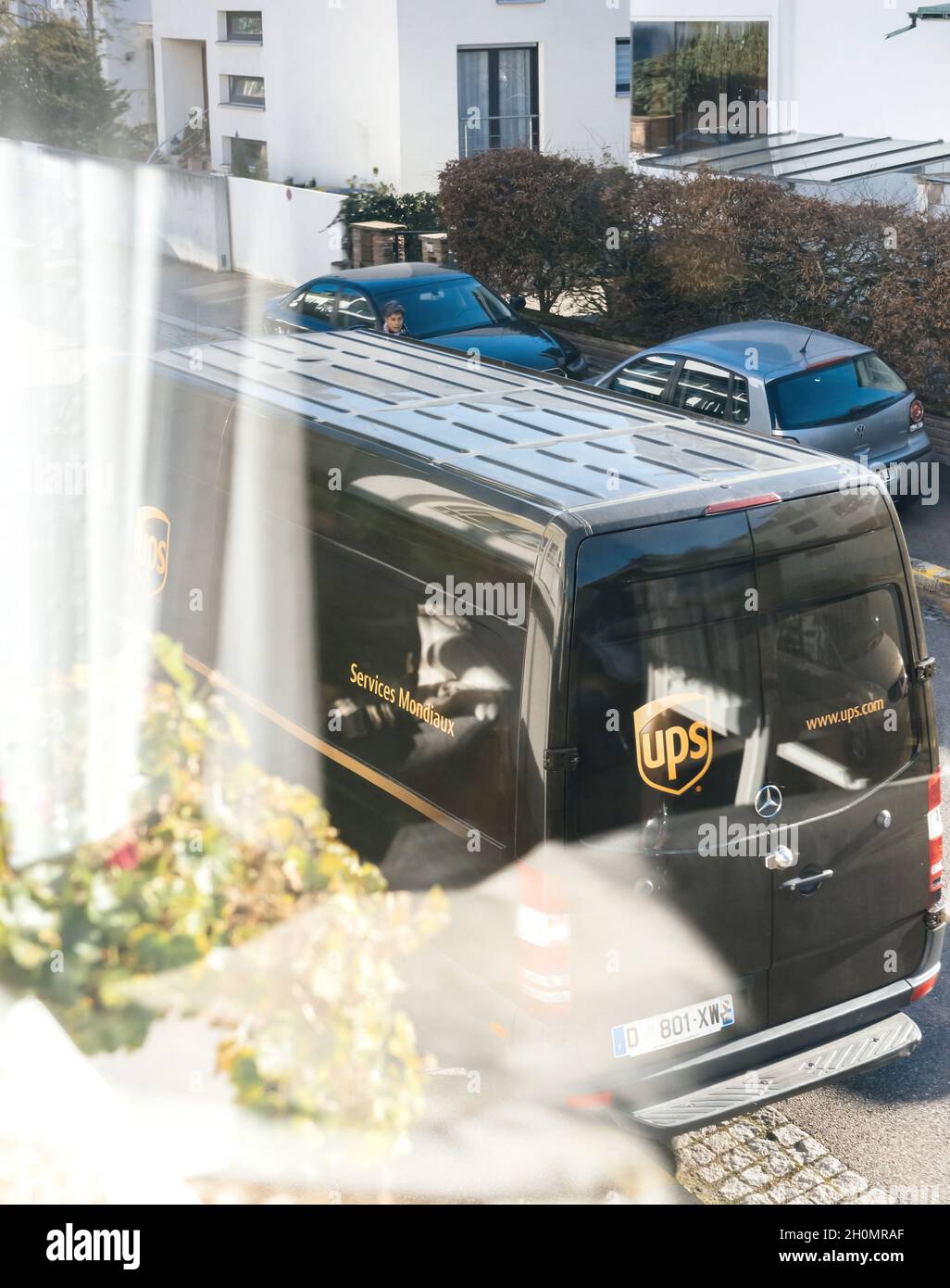 Aerial view of UPS driver next to his brown Mercedes van loading ...