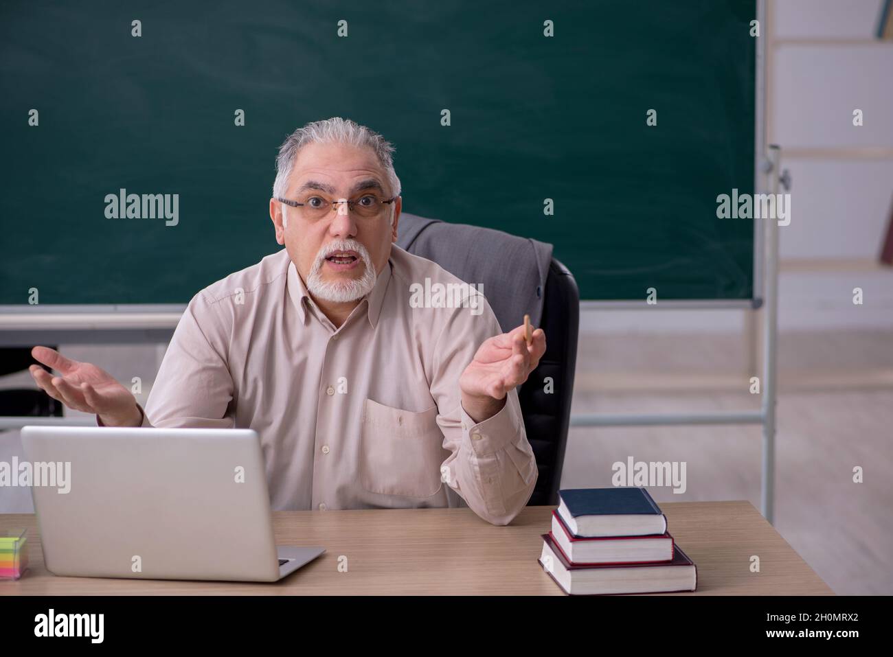 Old teacher in front of blackboard Stock Photo - Alamy