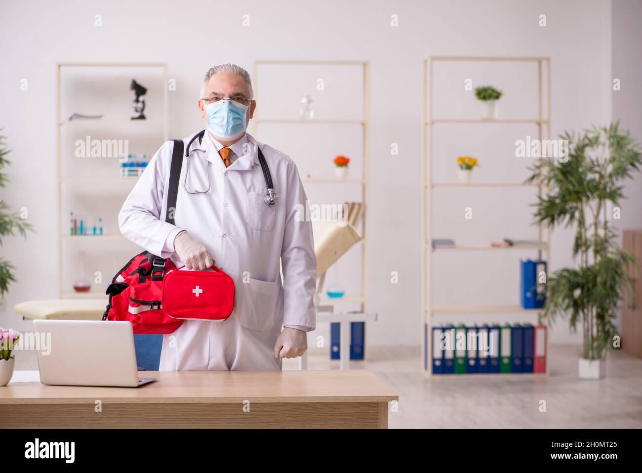 Old doctor in first aid concept Stock Photo - Alamy