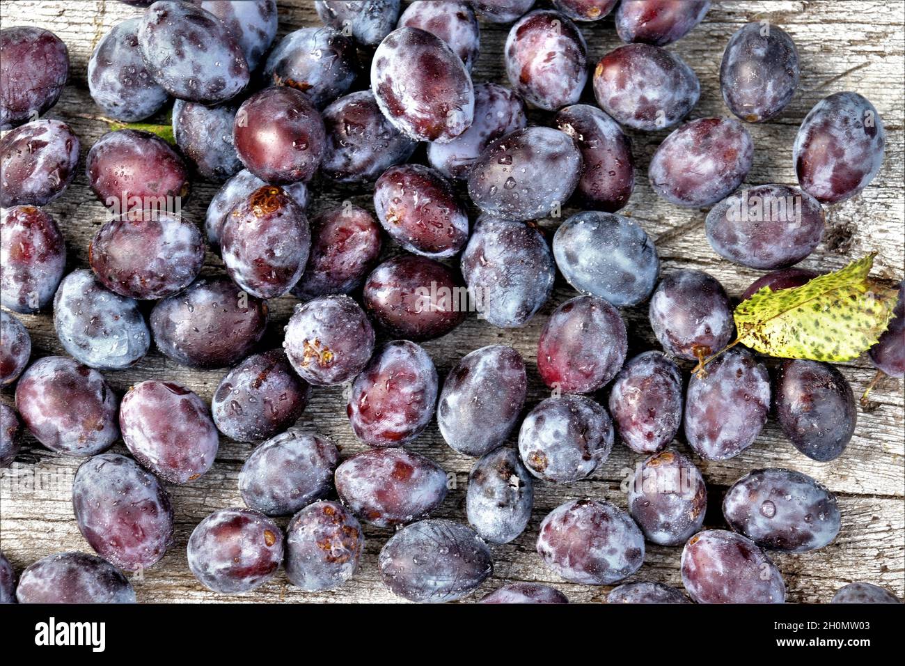 Fresh ripe plums on old rustic board Stock Photo - Alamy