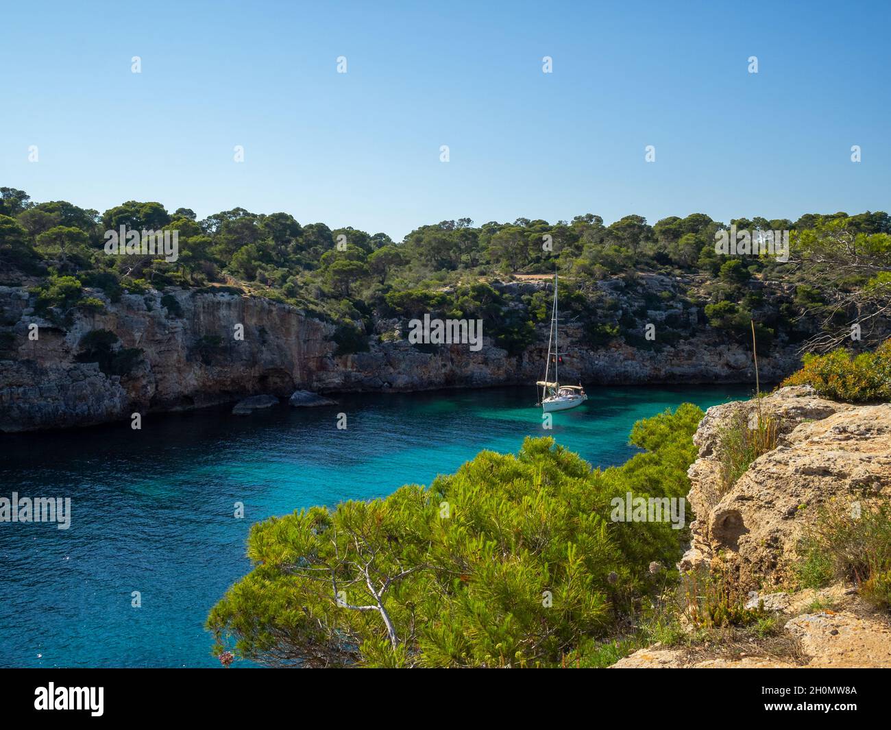 A sailboat floating in the turquoise waters of Cala Pi, Maiorca Stock ...