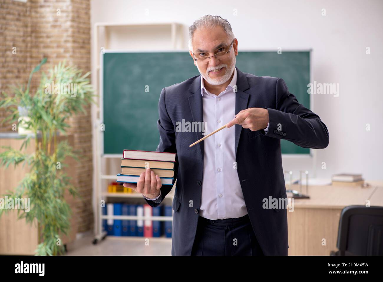 Old teacher in front of blackboard Stock Photo - Alamy