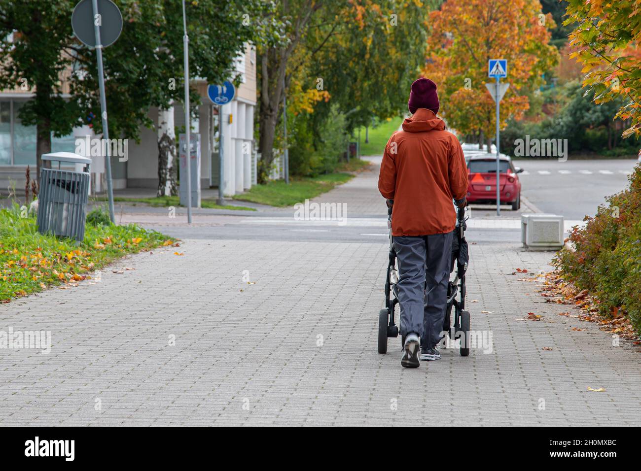Shot of a person with a stroller walking outdoors with road signs and ...