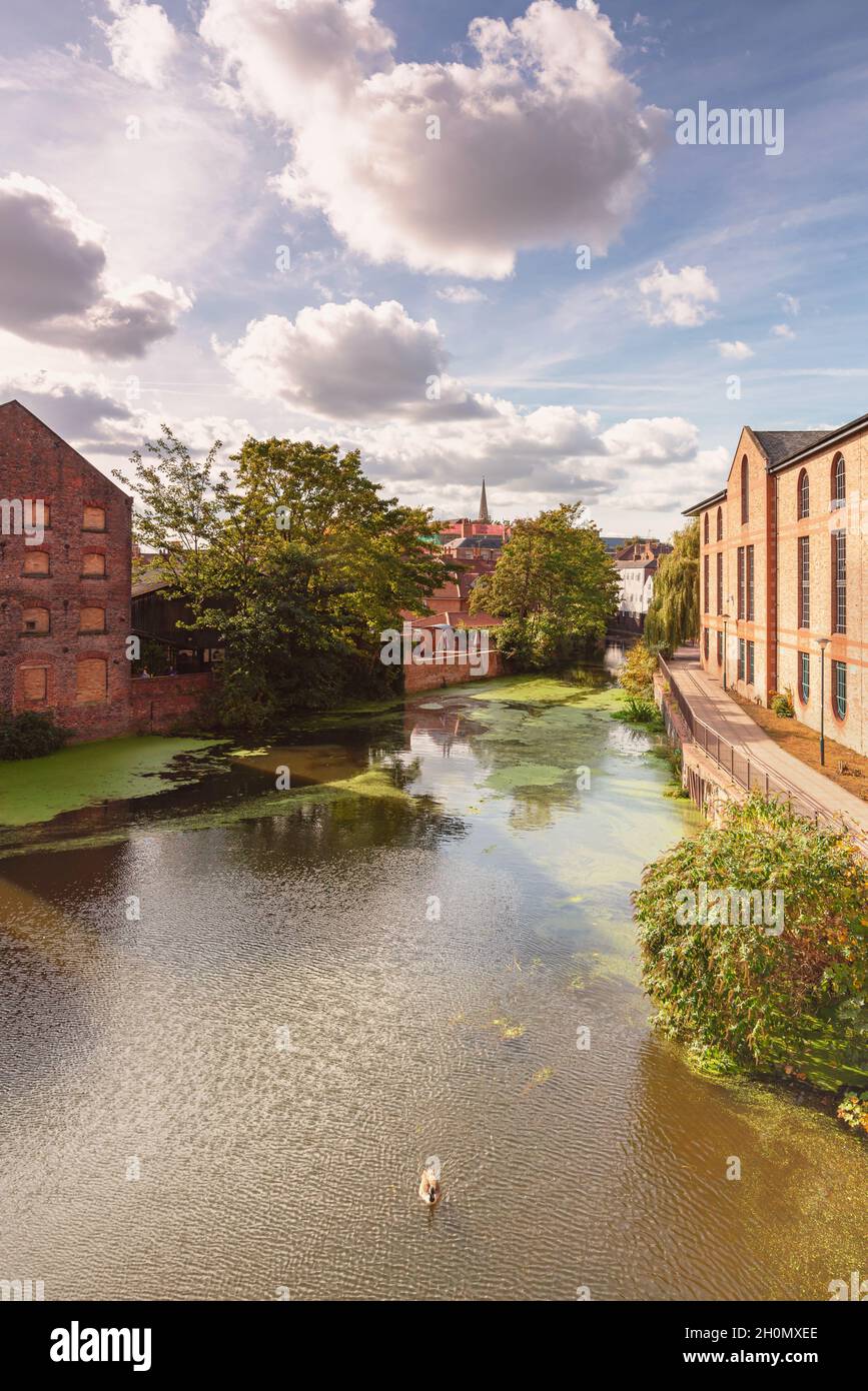 Panoramic view along a river. Buildings are on either side and roofs of ...