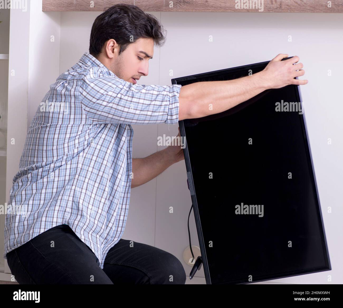 The man repairing broken tv at home Stock Photo - Alamy